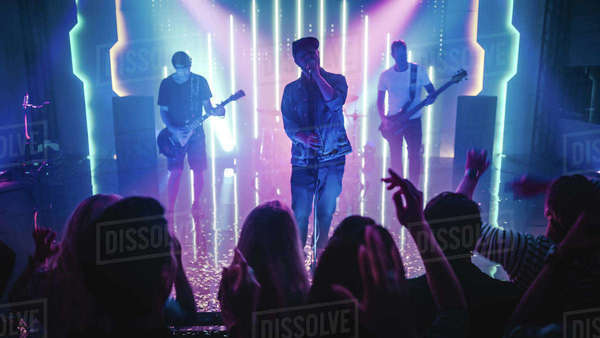 Rock Band with Guitarists and Drummer Performing at a Concert in a ...