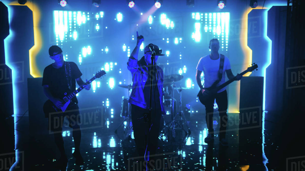 Rock Band with Guitarists and Drummer Performing at a Concert in a ...