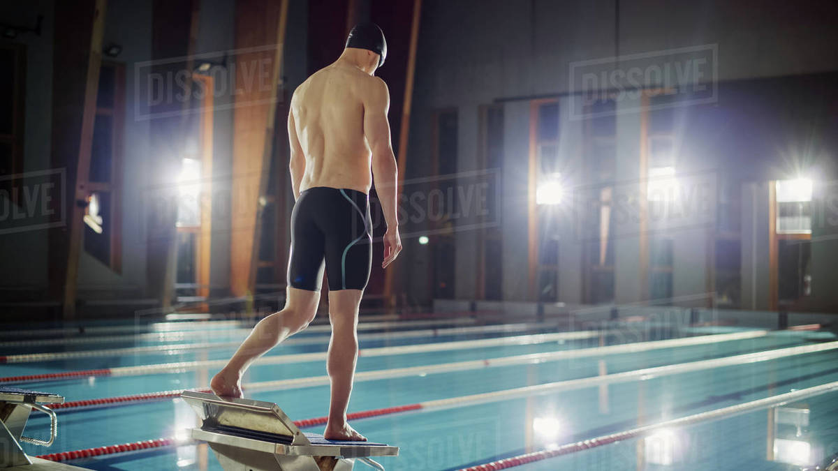 Athletic Male Swimmer Stands on a Starting Block, Ready to Dive into ...