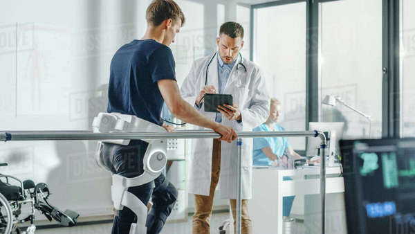 Modern Hospital Physical Therapy: Doctor Uses Tablet Computer, Helps ...