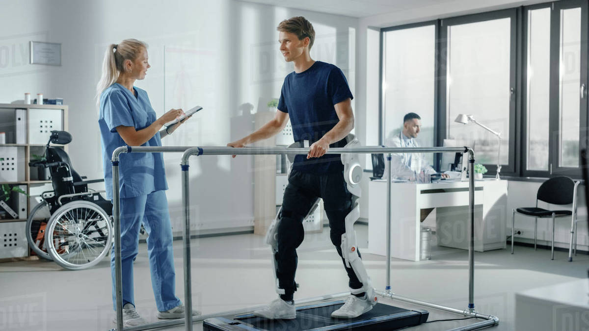 Modern Hospital Physical Therapy: Doctor Uses Tablet Computer, Helps ...