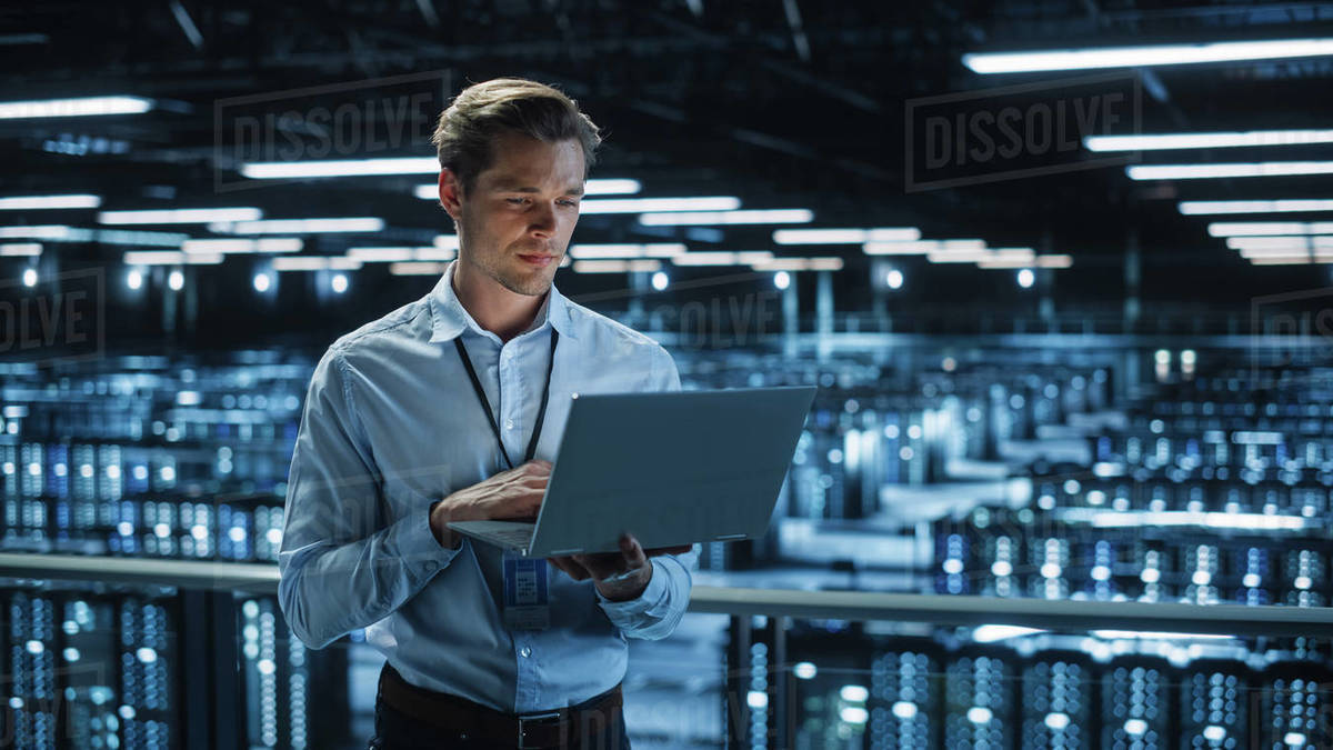 Smiling IT Specialist Using Laptop Computer in Data Center - Royalty ...