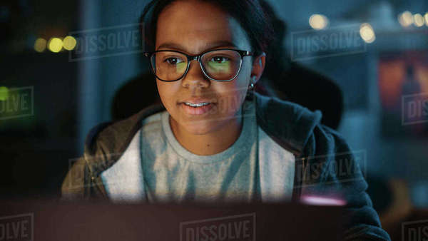 Young Teenage Black Girl Using Laptop Computer in a Dark Cozy Room at ...
