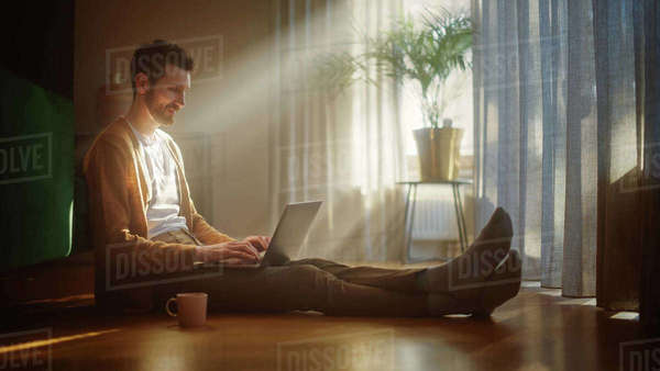 Man Using Laptop at Home for Remote Work - Stock Photo - Dissolve