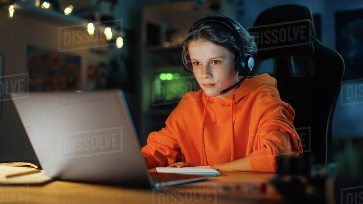 Young Boy in Headphones Attending Online Class on Laptop Computer in ...