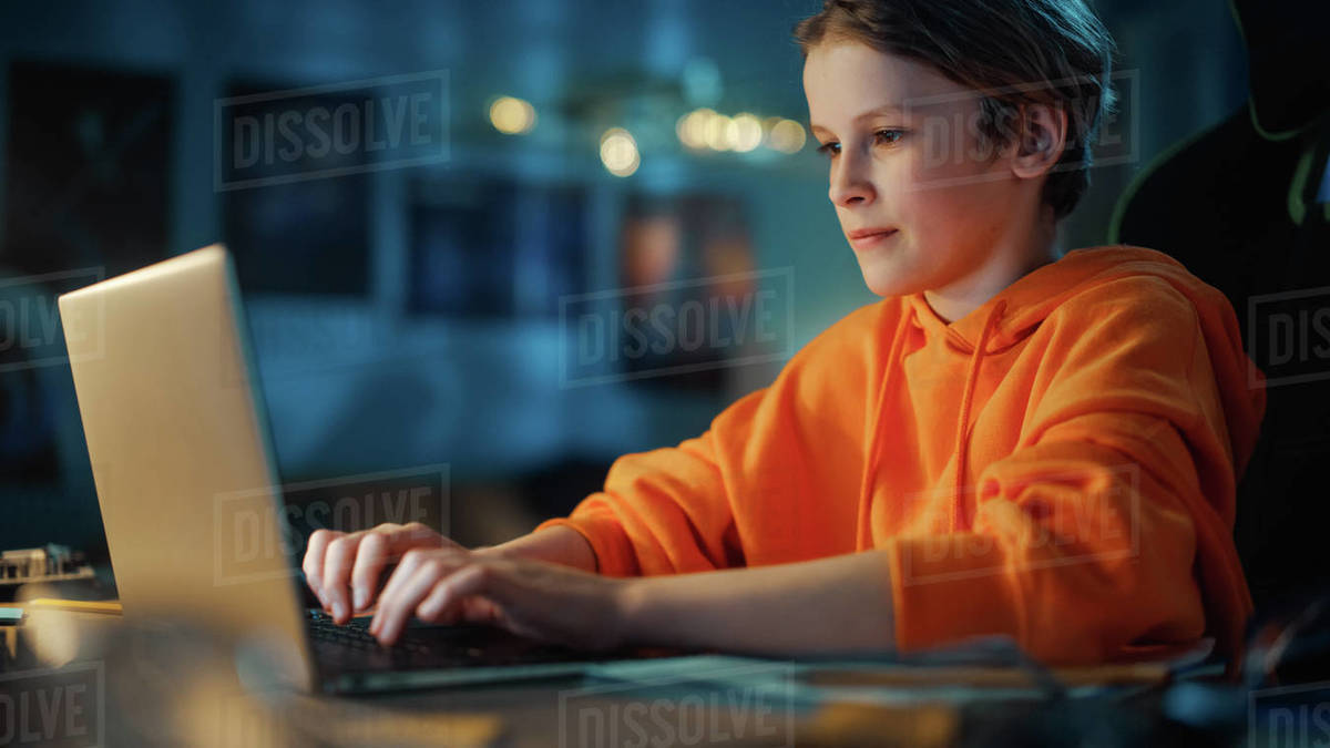Young Boy Using Laptop Computer in a Dark Cozy Room at Home - Stock ...