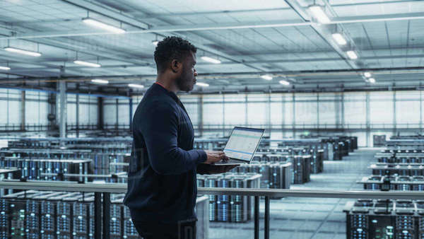 Data Center Engineer Using Laptop Computer - Stock Photo - Dissolve