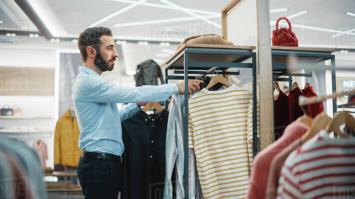 Male Clothing Store Assistant Works in Fashionable Shopping Mall ...