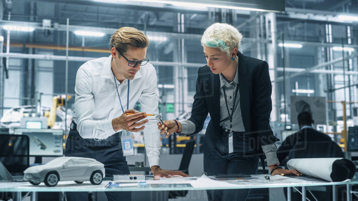 Two Young Automotive Engineers Working in Office at Car Factory ...