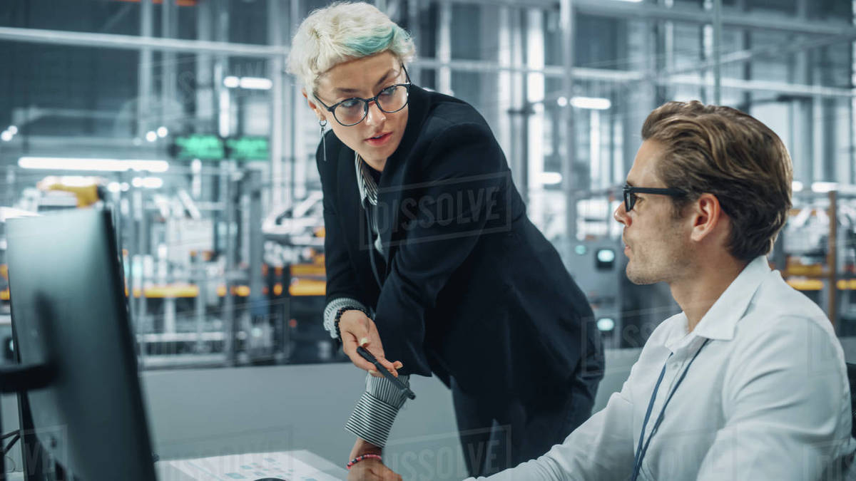 Two Automotive Engineers Discussing Concept Car Blueprints on Desktop ...