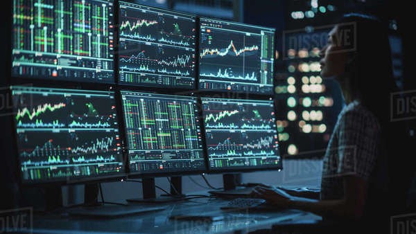 Financial Analyst Working on a Computer with Multi-Monitor Workstation ...