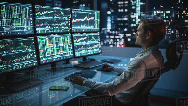 Financial Analyst Working on a Computer with Multi-Monitor Workstation ...