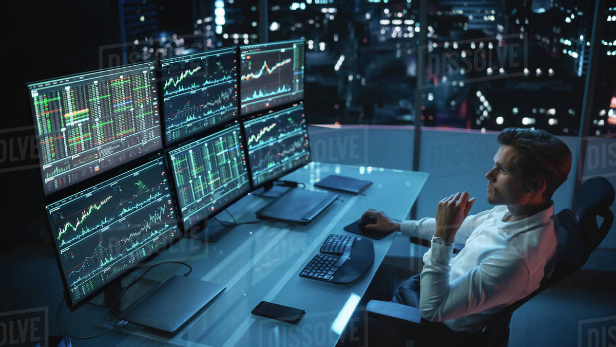 Financial Analyst Working on a Computer with Multi-Monitor Workstation with Real-Time Stocks ...