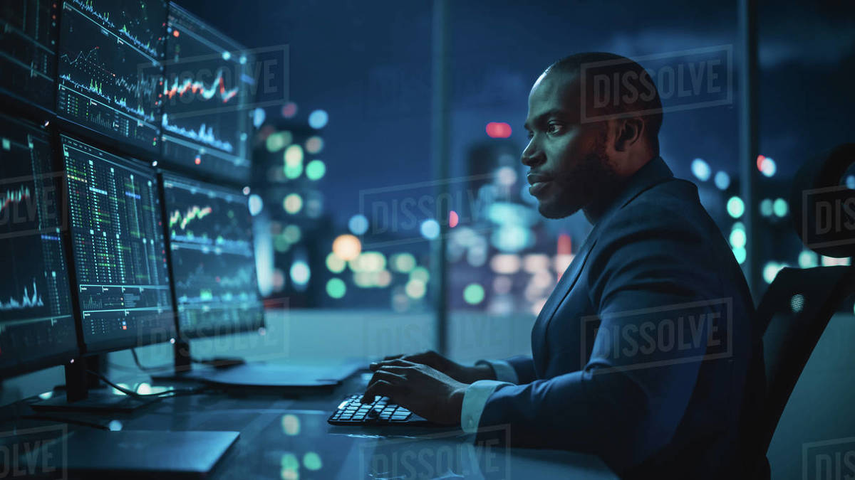 Financial Analyst Working on Computer with Multi-Monitor Workstation ...