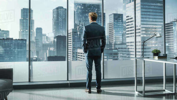 Businessman Standing Next to a Window in a Modern Office - Royalty-free ...