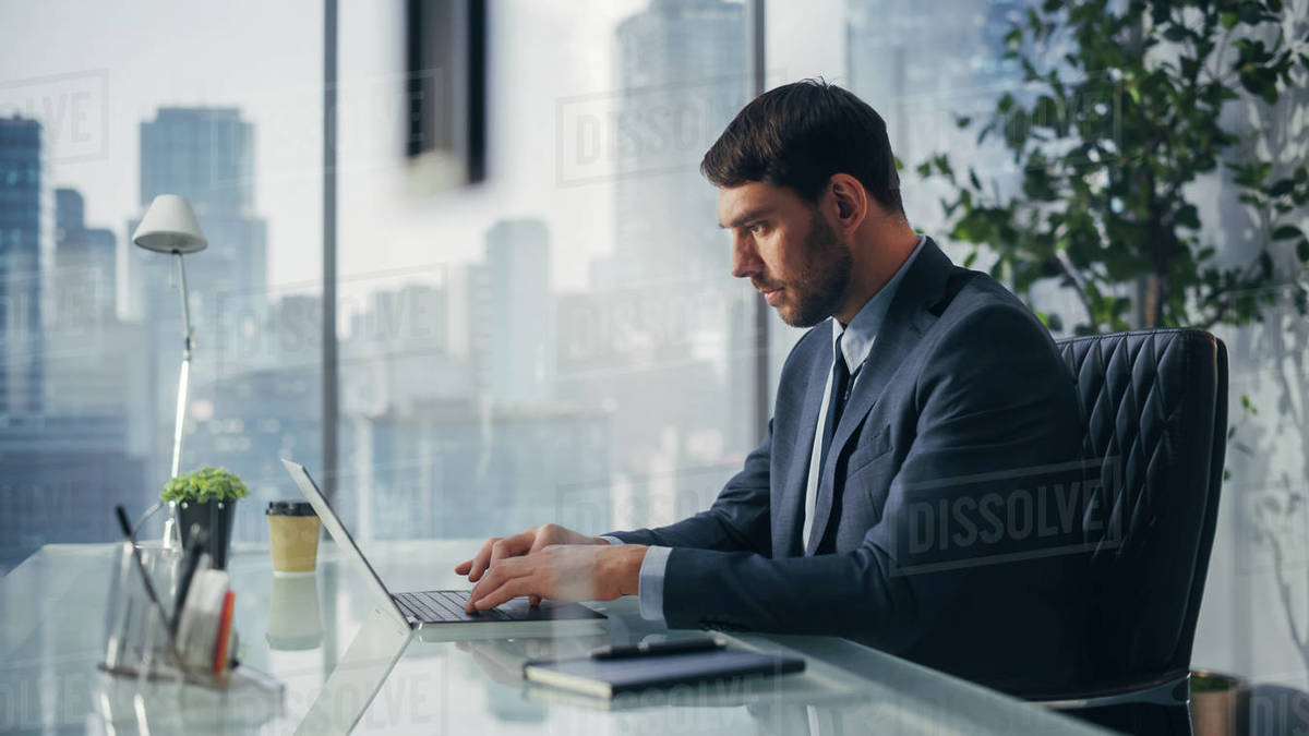 Businessman in a Suit Sitting at a Desk in Modern Office - Royalty-free ...
