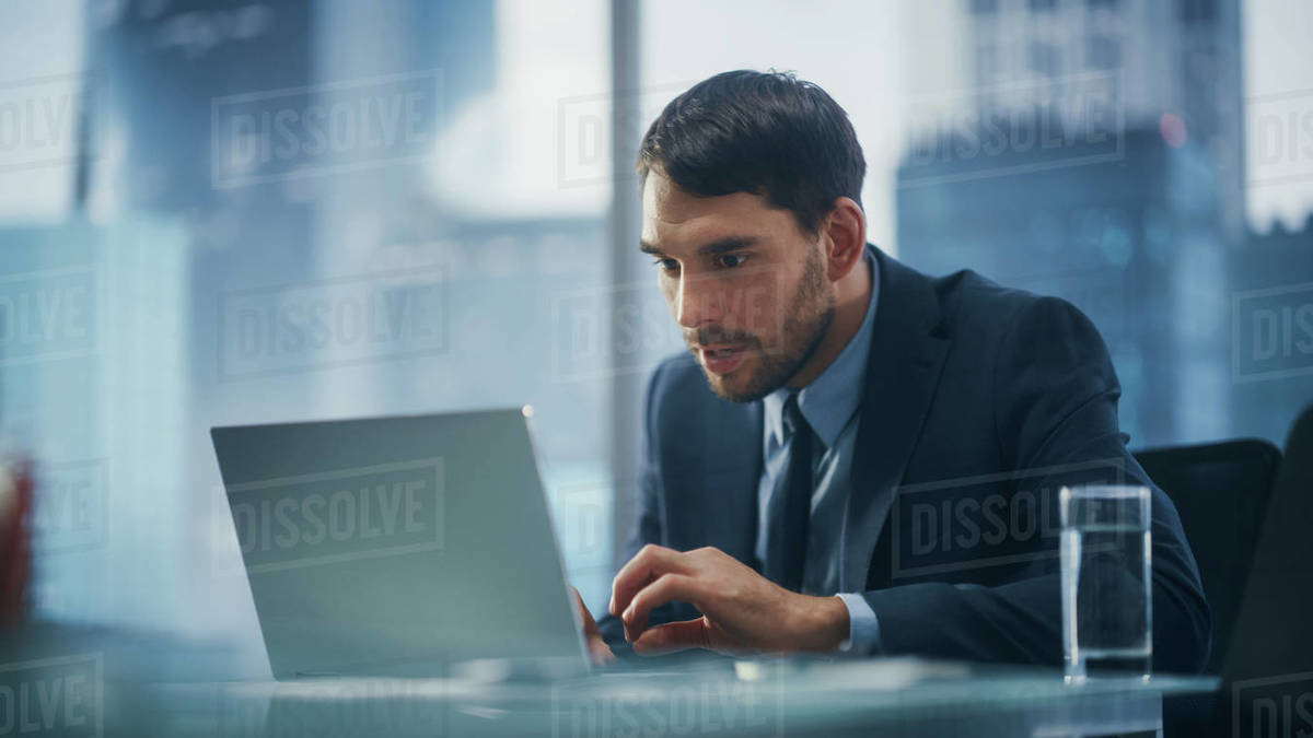 Businessman in a Suit Sitting at a Desk in Modern Office - Royalty-free ...