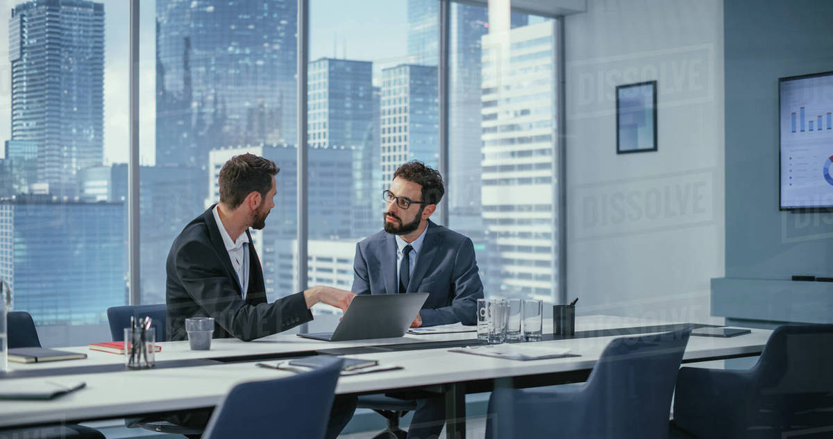 Business Meeting of Two Businessmen Using Laptop Computer and Talking ...