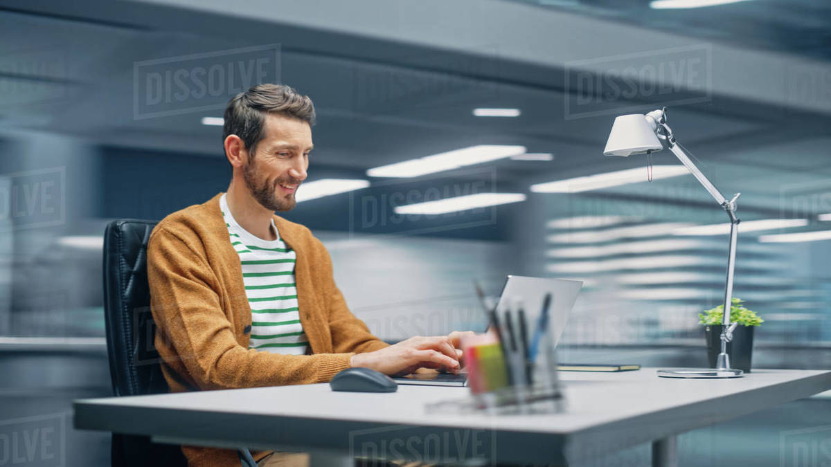 Businessman Sitting at His Desk Working on a Laptop Computer - Royalty ...