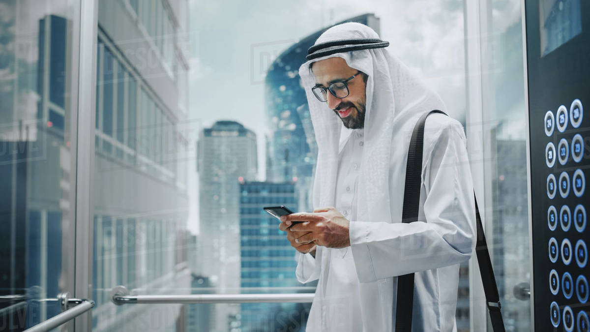 Successful Muslim Businessman in Traditional White Kandura Riding Glass ...