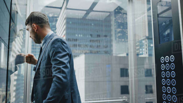 Stressed Out Manager Going Down from Office in a Glass Elevator in ...