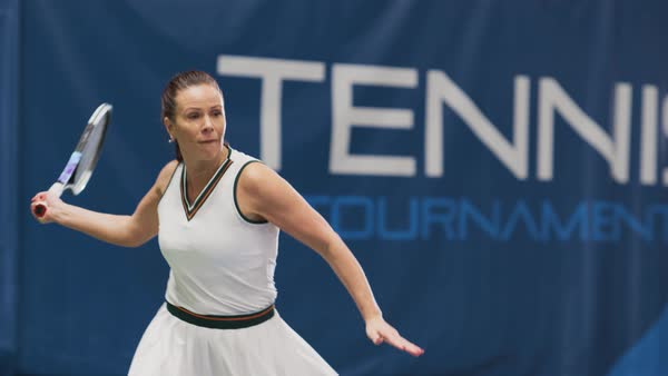 Female Tennis Player Hitting Ball with a Racquet During Championship ...