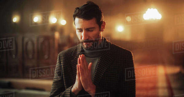 Young Christian Man on his Knees in Church, with Folded Hands. Praying ...