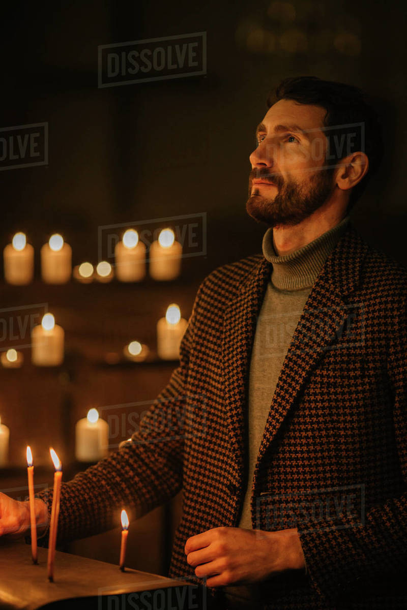 Devout Christian Man Lighting a Candle in Church, Praying and ...