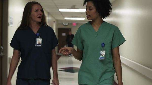 Medium shot of two nurses walking through hospital corridor - HD ...