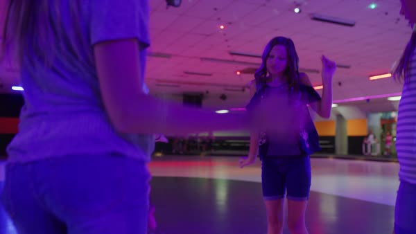Slow motion shot of girls dancing and singing in circle at roller ...