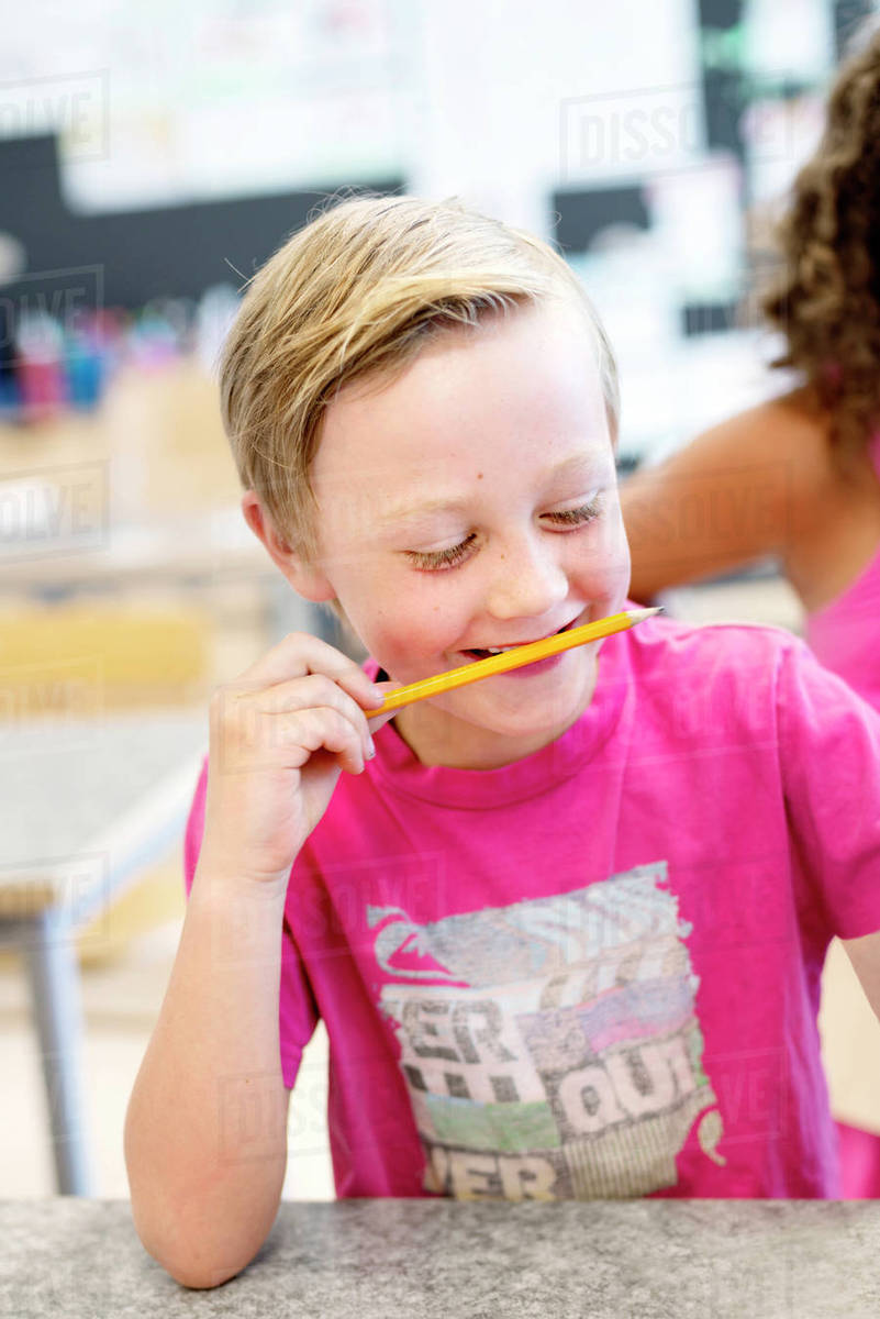 Boy holding pencil in mouth - Royalty-free Stock Photo | Dissolve