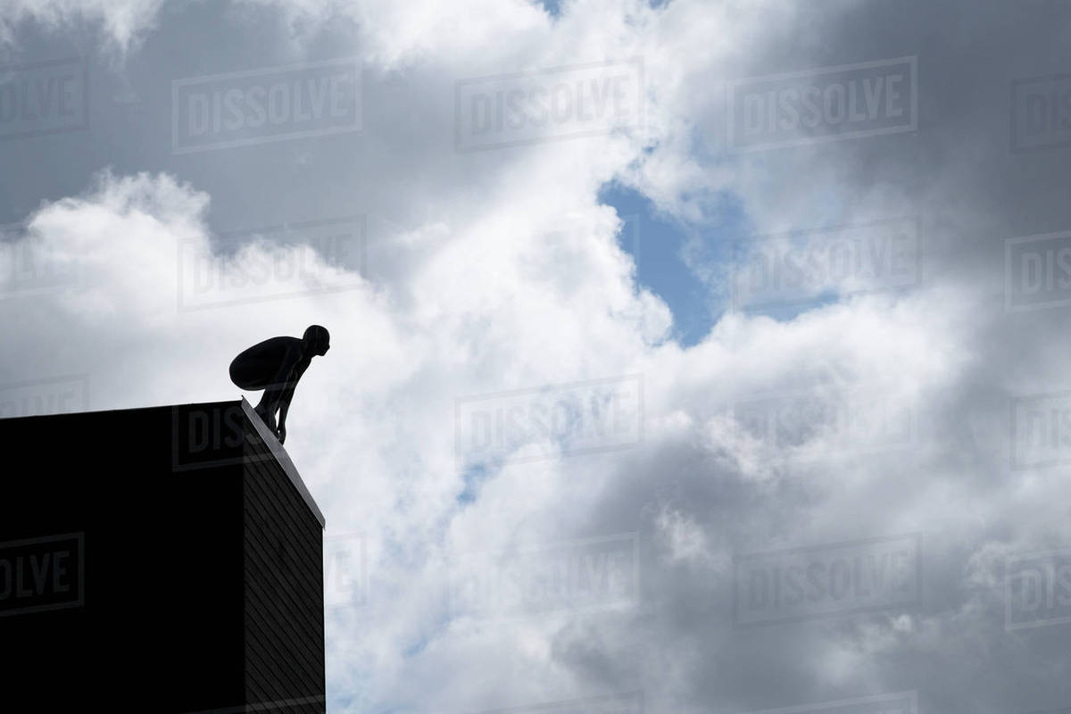Silhouette of man standing on rooftop - Royalty-free Stock Photo | Dissolve