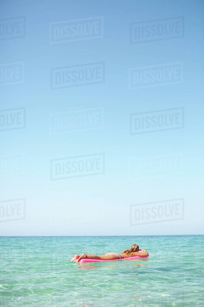 Woman floating in inflatable mattress - Royalty-free Stock Photo | Dissolve