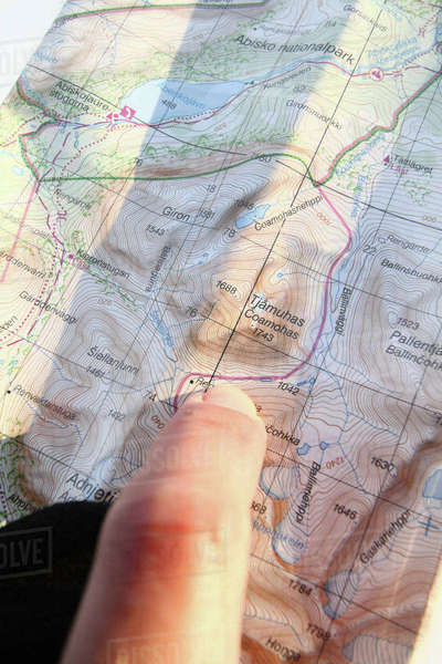 Finger pointing on map, close-up - Royalty-free Stock Photo | Dissolve