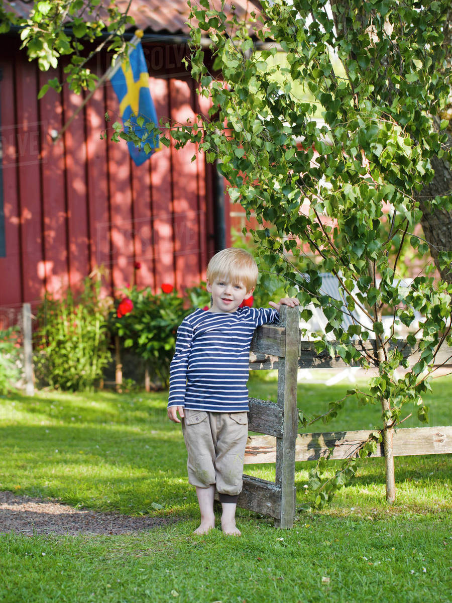 Boy standing in garden - Royalty-free Stock Photo | Dissolve