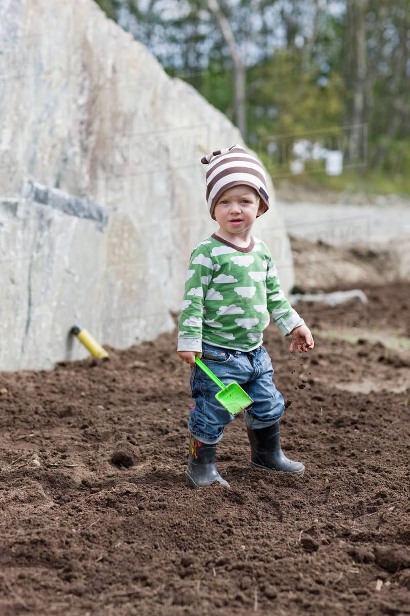 Boy digging in soil - Royalty-free Stock Photo | Dissolve