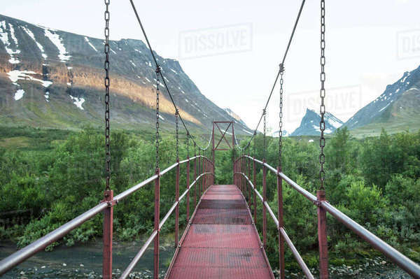 Hanging footbridge in mountains - Stock Photo - Dissolve