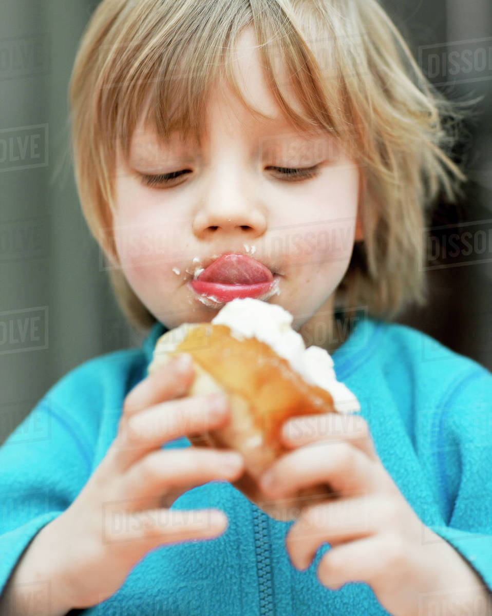 Boy eating bun - Royalty-free Stock Photo | Dissolve