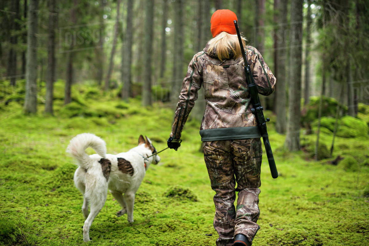 Woman with hunting dog in forest - Royalty-free Stock Photo | Dissolve