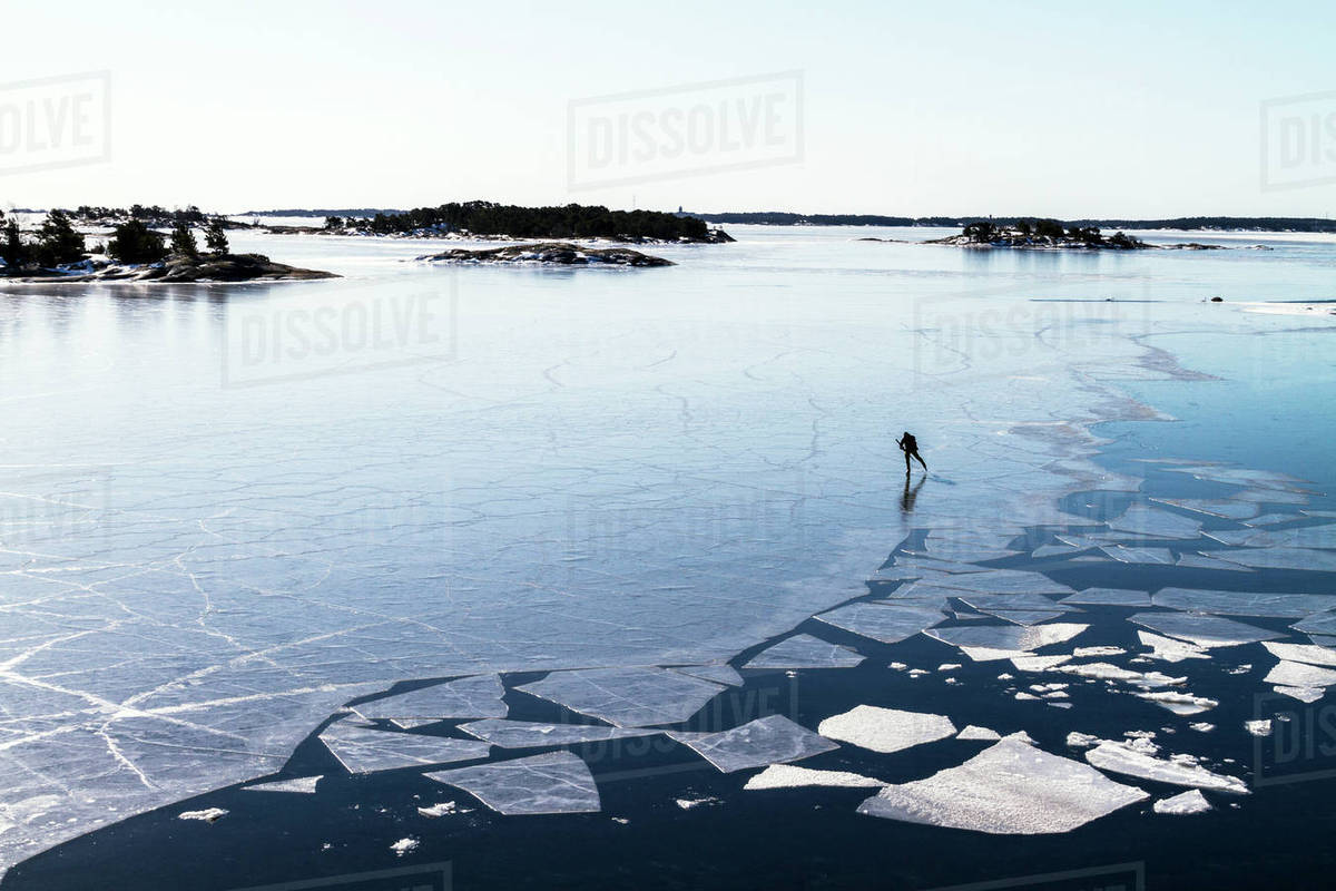Person ice-skating on frozen water - Royalty-free Stock Photo | Dissolve