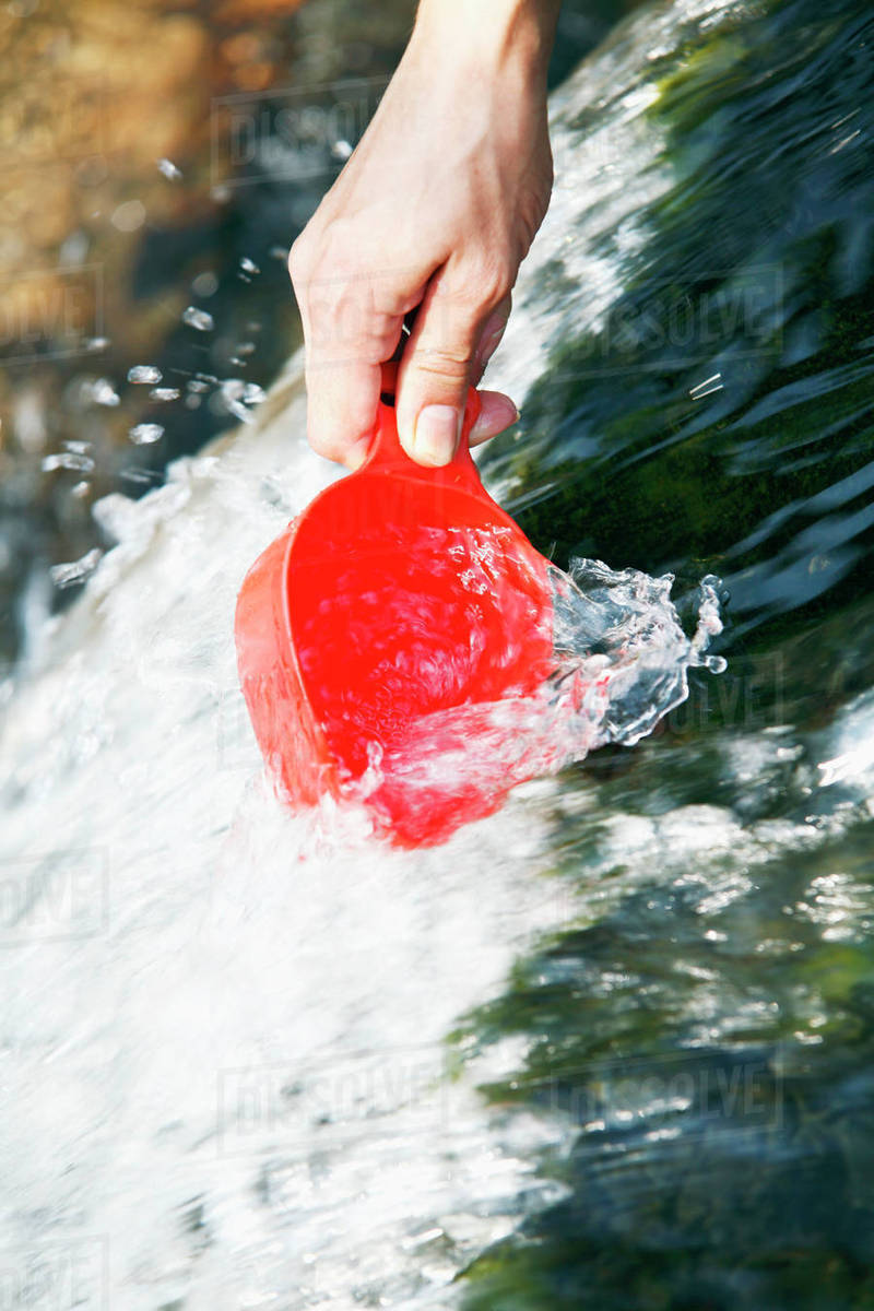 Hand taking water from river - Stock Photo - Dissolve