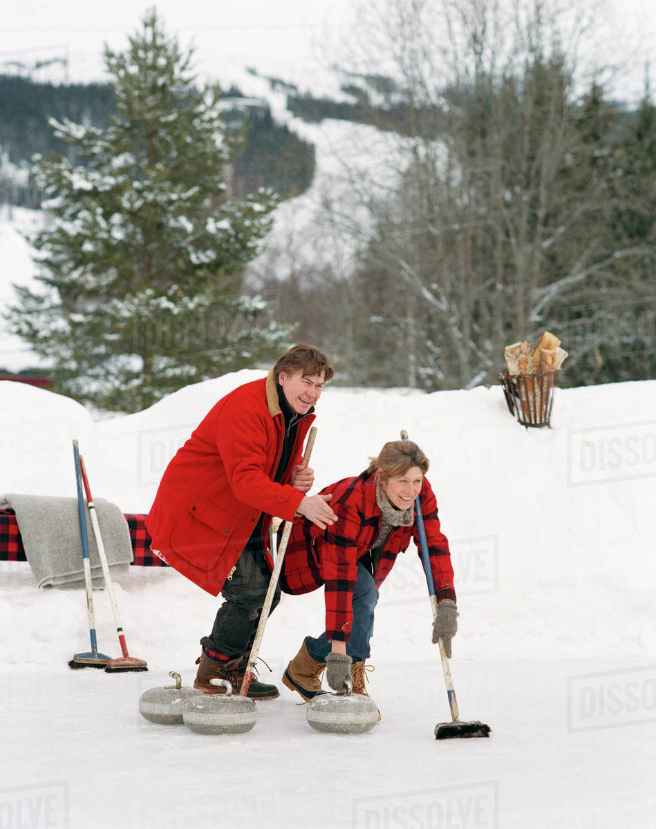Couple playing curling - Royalty-free Stock Photo | Dissolve