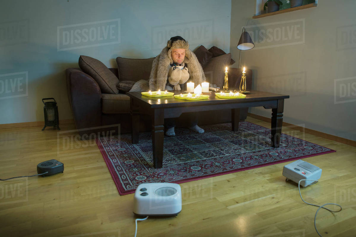 Man sitting in cold living room - Royalty-free Stock Photo | Dissolve