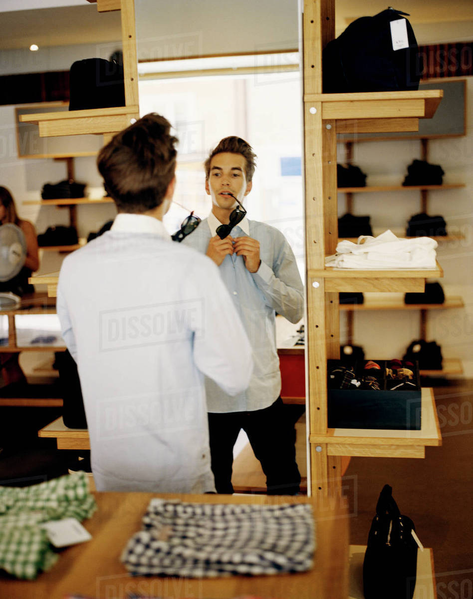 A man trying on a shirt - Royalty-free Stock Photo | Dissolve