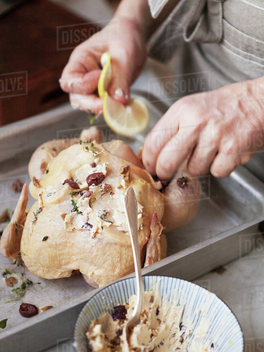 Woman preparing chicken for roast, close-up - Stock Photo - Dissolve
