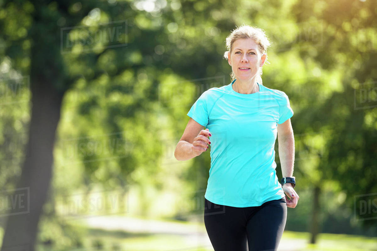 Woman jogging in park - Stock Photo - Dissolve