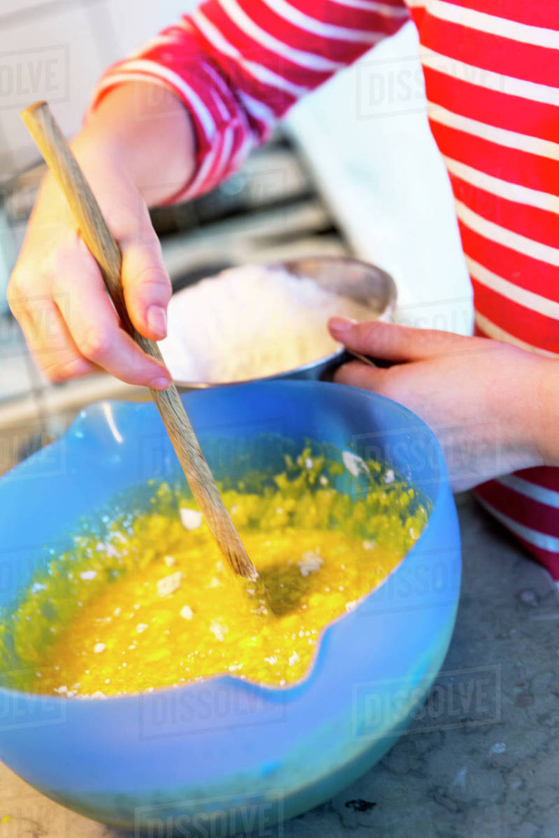 Close-up of child mixing food - Stock Photo - Dissolve