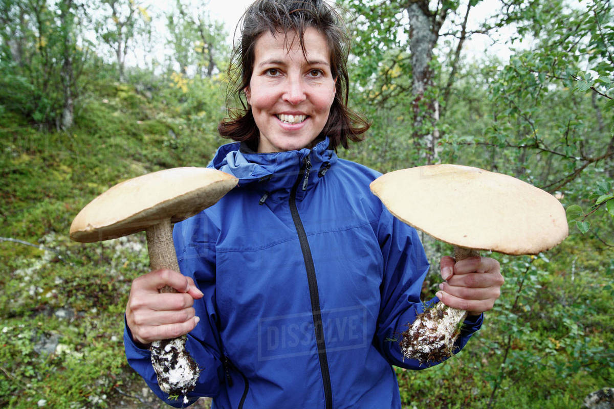 Smiling woman holding huge mushrooms in forest - Royalty-free Stock ...