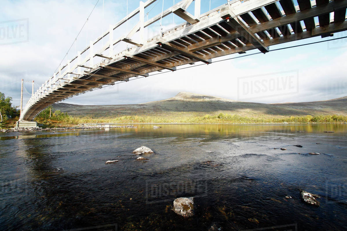Footbridge above river - Stock Photo - Dissolve