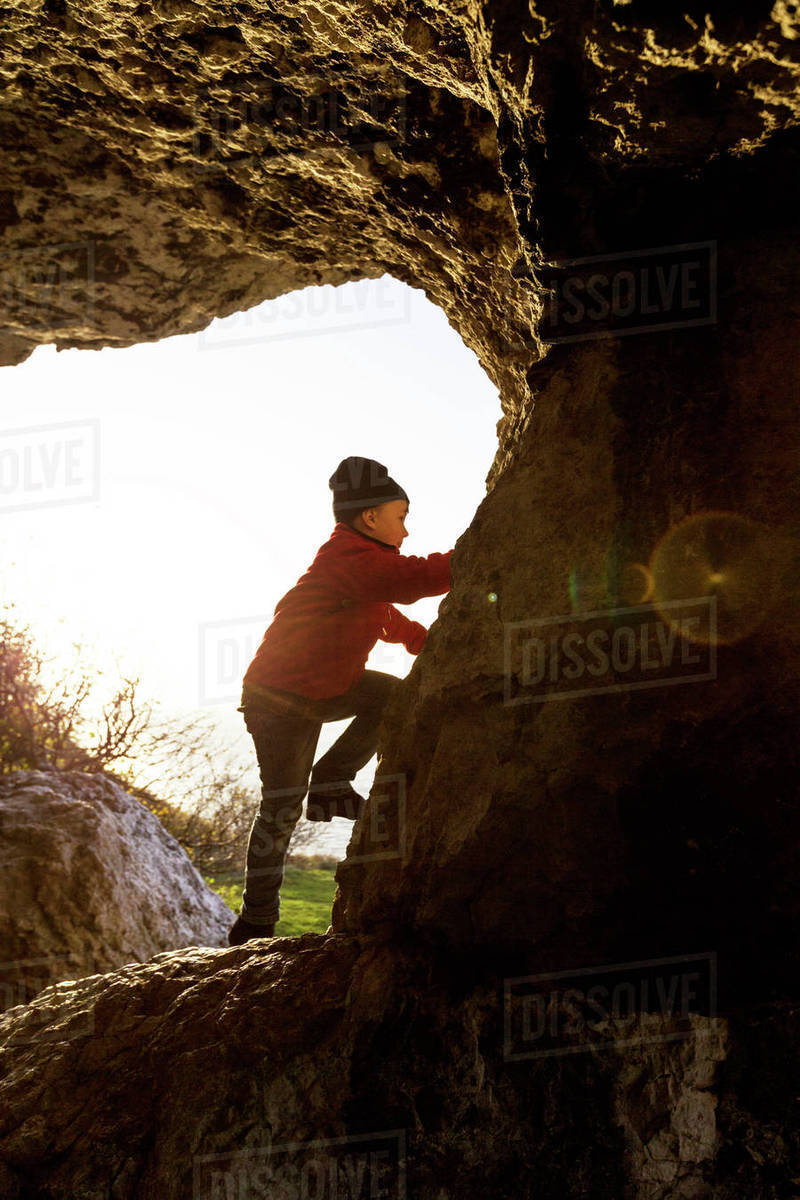 Boy climbing on rock - Royalty-free Stock Photo | Dissolve